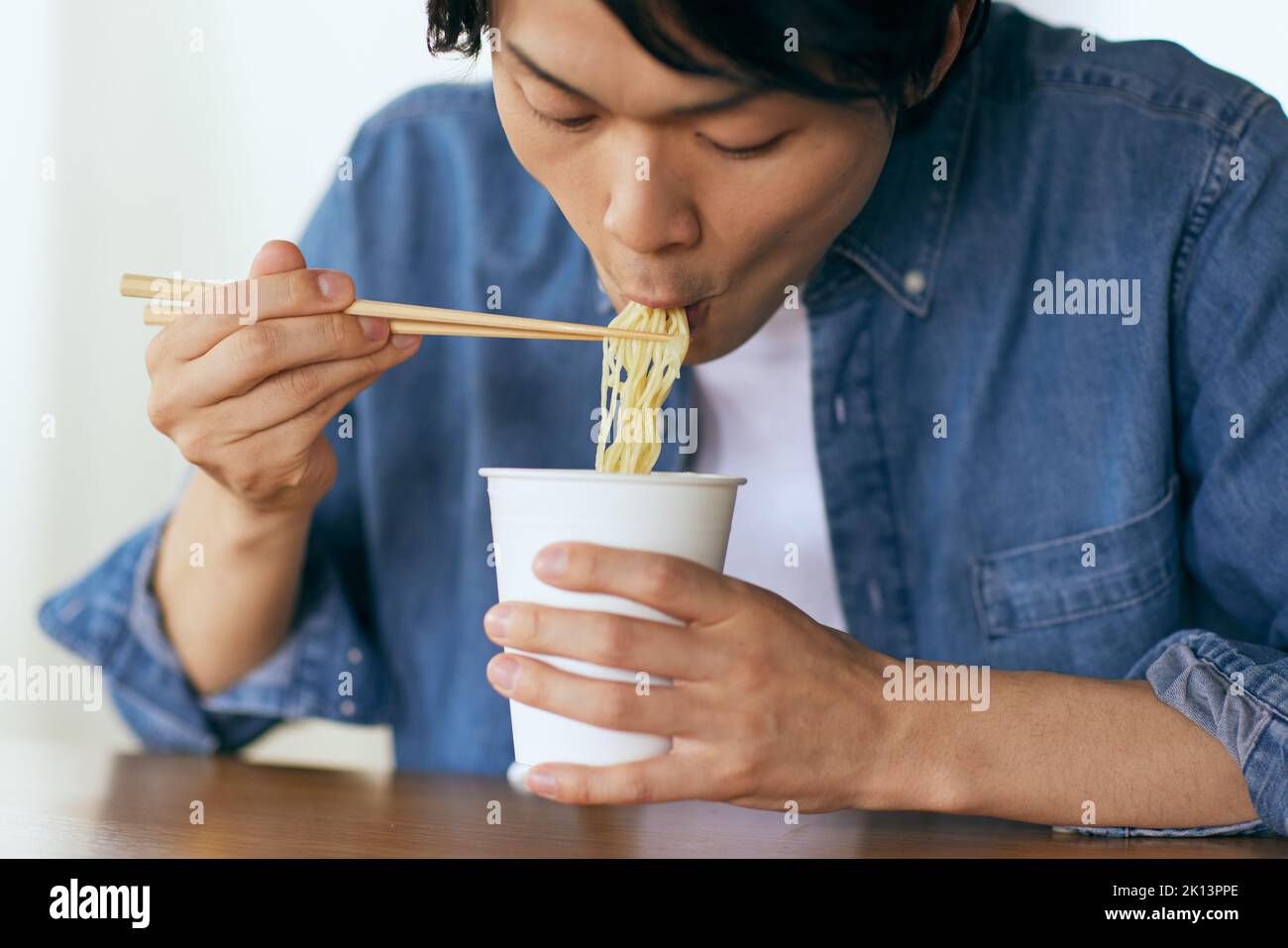Young male eating ramen noodles hi-res stock photography and images - Alamy