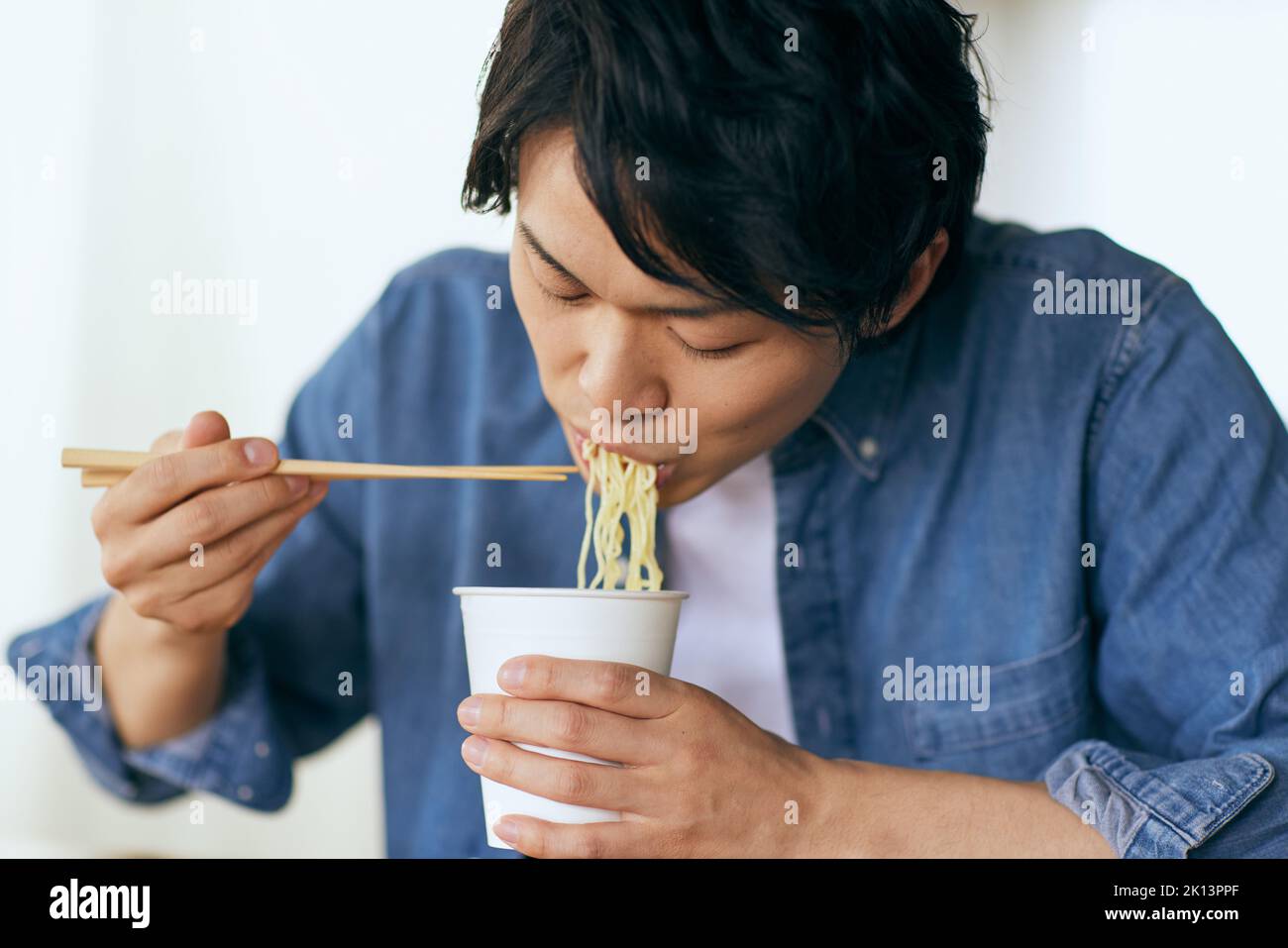 Young male eating ramen noodles hi-res stock photography and images - Alamy