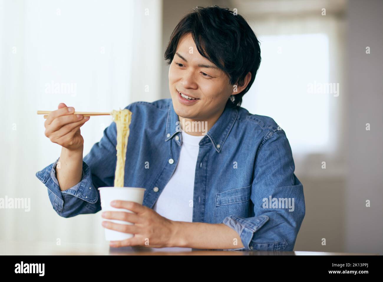 Young male eating ramen noodles hi-res stock photography and images - Alamy