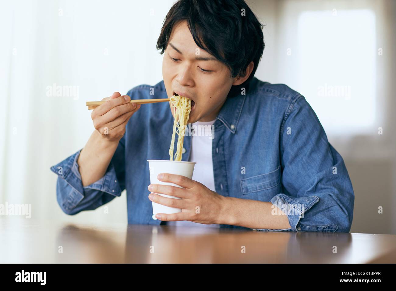 Young male eating ramen noodles hi-res stock photography and images - Alamy