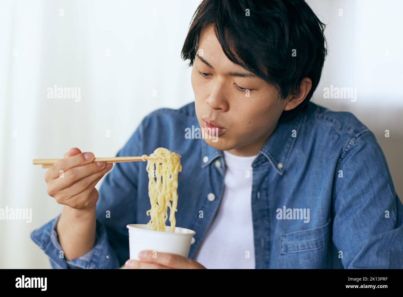 Young male eating ramen noodles hi-res stock photography and images - Alamy
