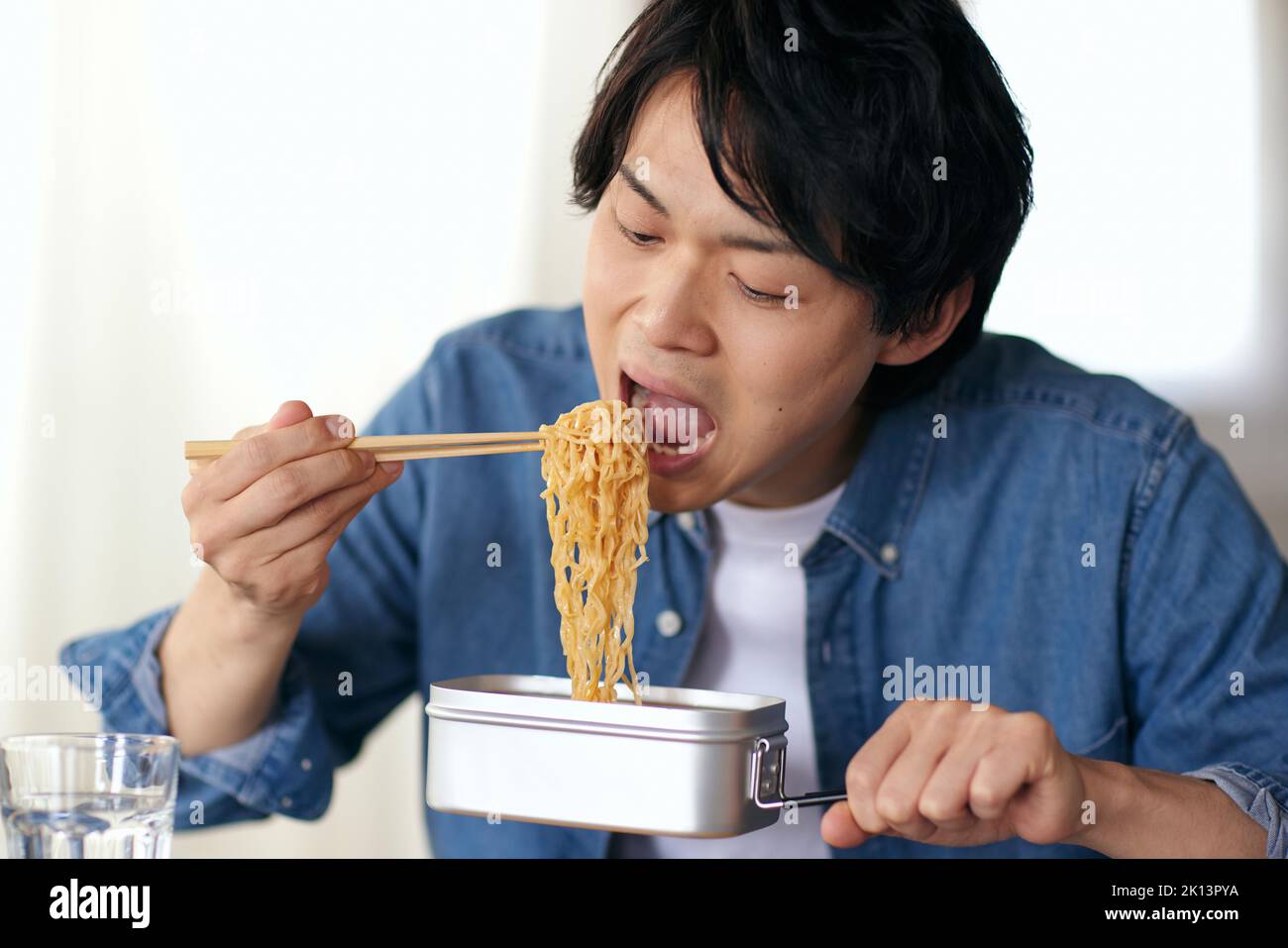 Young male eating ramen noodles hi-res stock photography and images - Alamy
