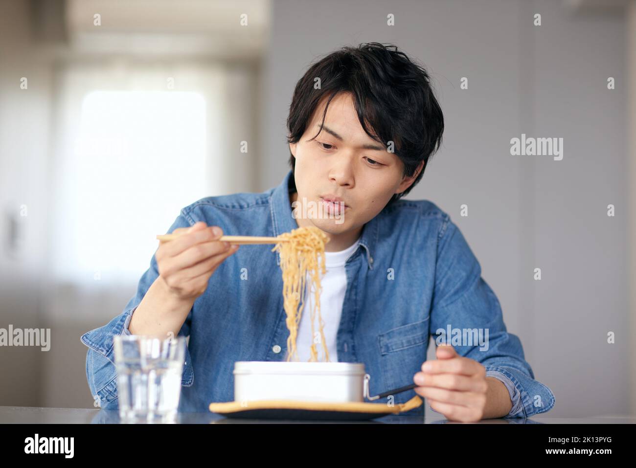 Young male eating ramen noodles hi-res stock photography and images - Alamy