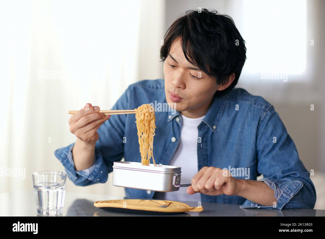 Young male eating ramen noodles hi-res stock photography and images - Alamy