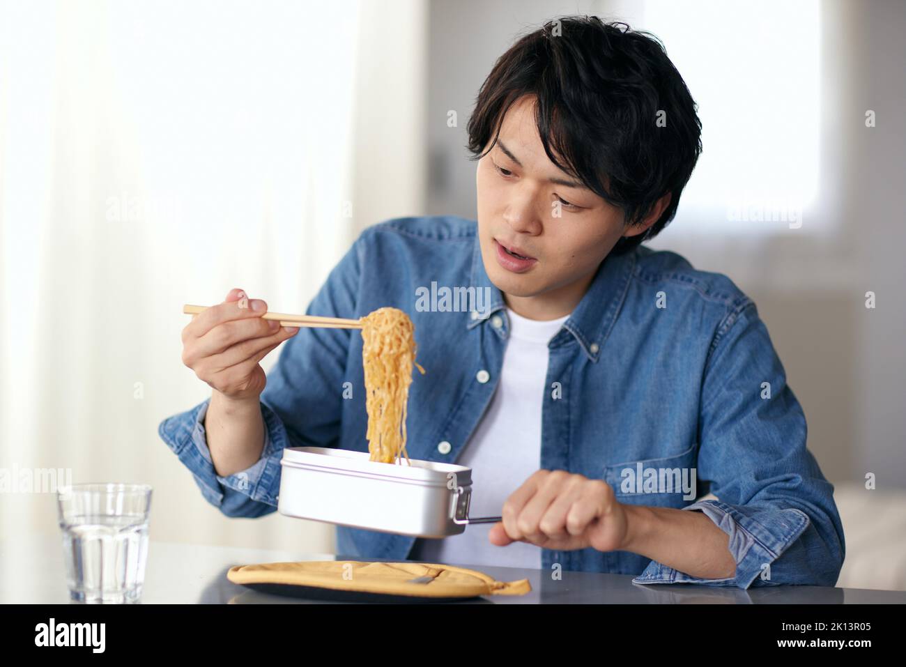 Young male eating ramen noodles hi-res stock photography and images - Alamy