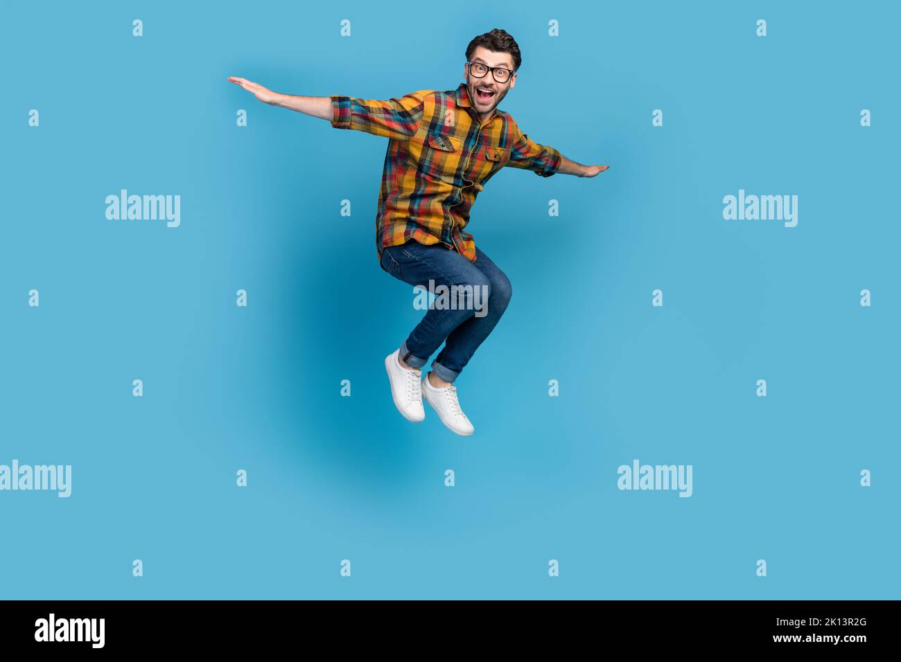 Full size portrait of active excited guy jumping arms wings flying ...
