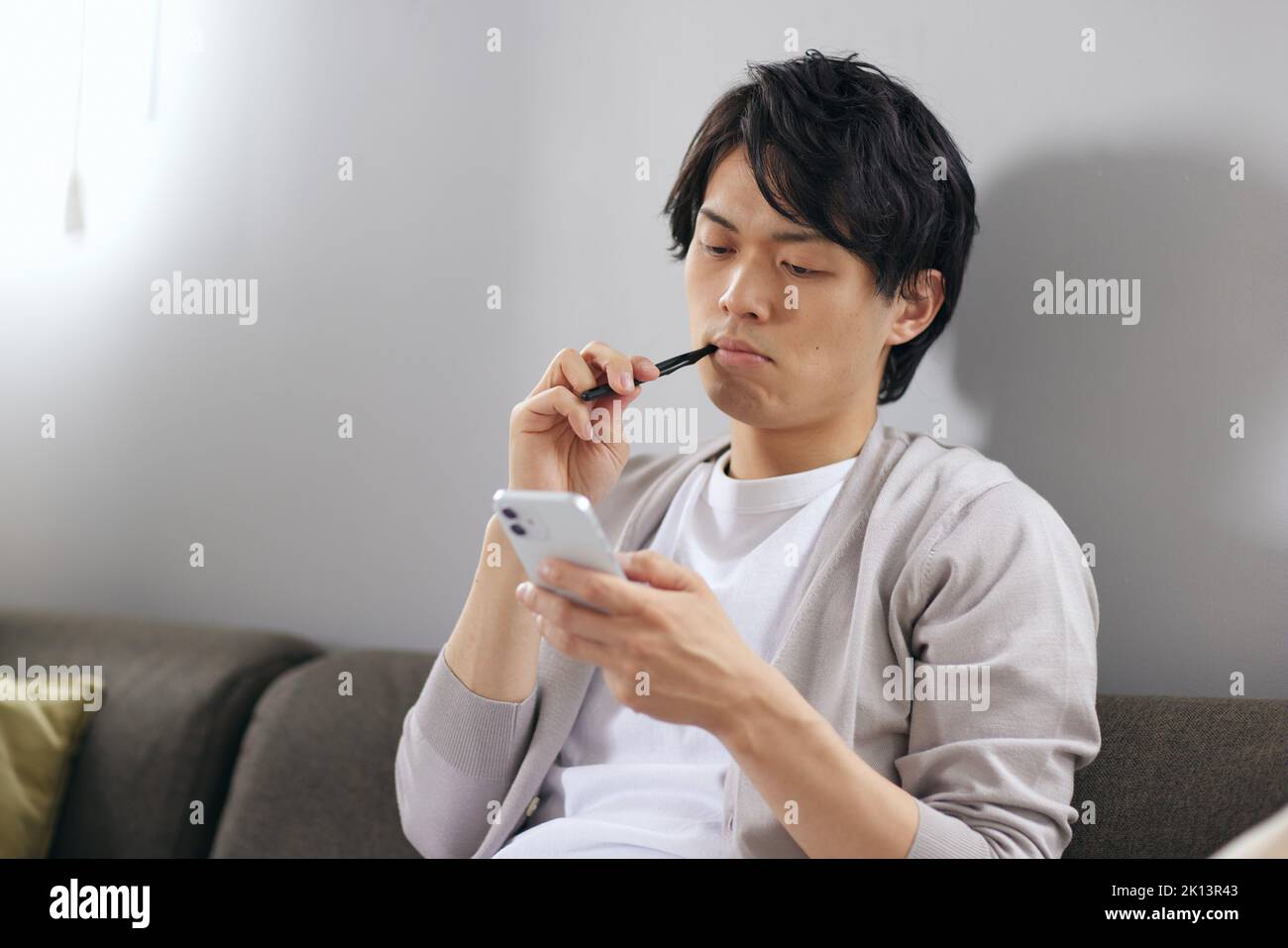 Japanese man brushing teeth on the sofa Stock Photo - Alamy