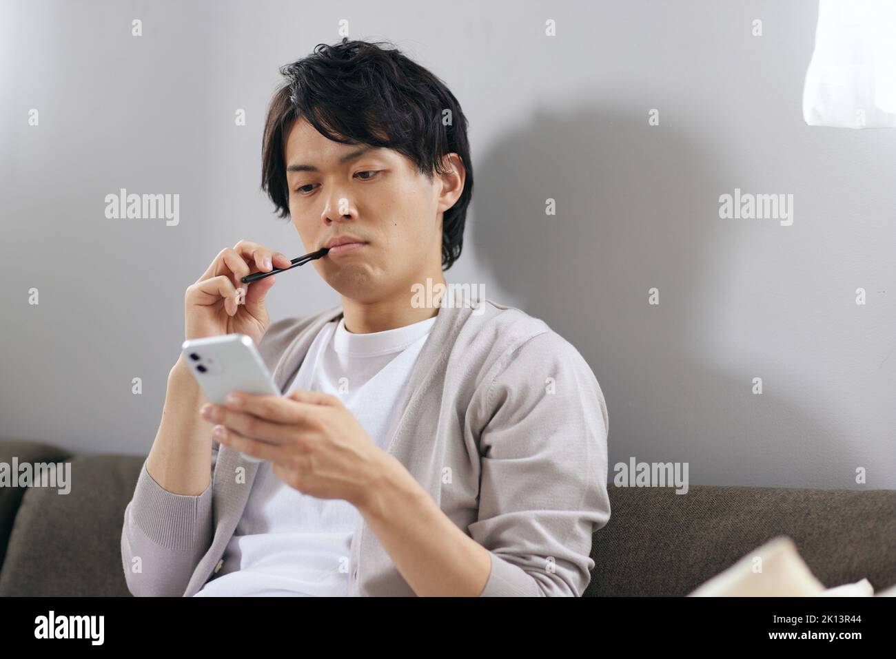 Japanese man brushing teeth on the sofa Stock Photo - Alamy