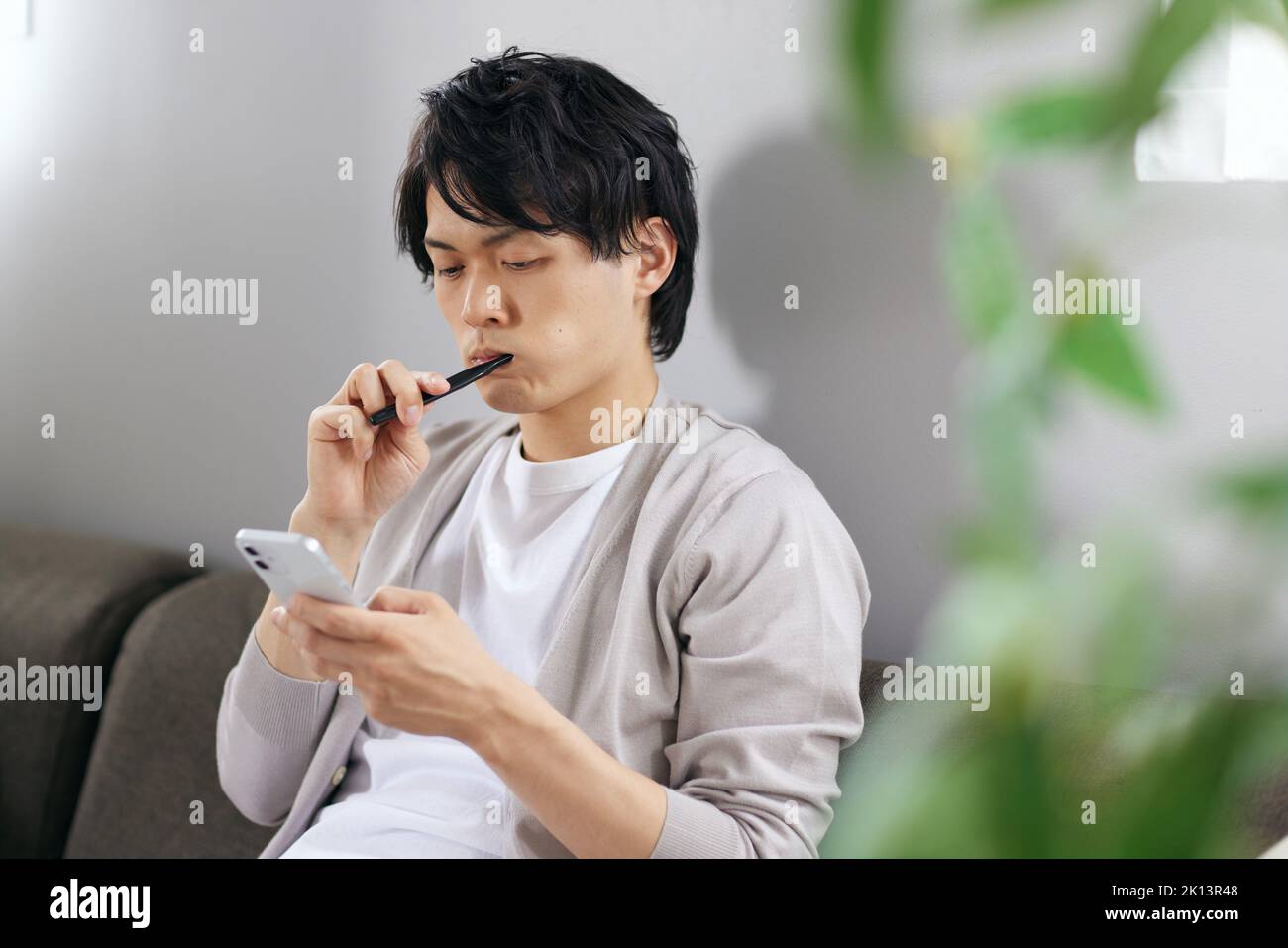 Japanese man brushing teeth on the sofa Stock Photo - Alamy