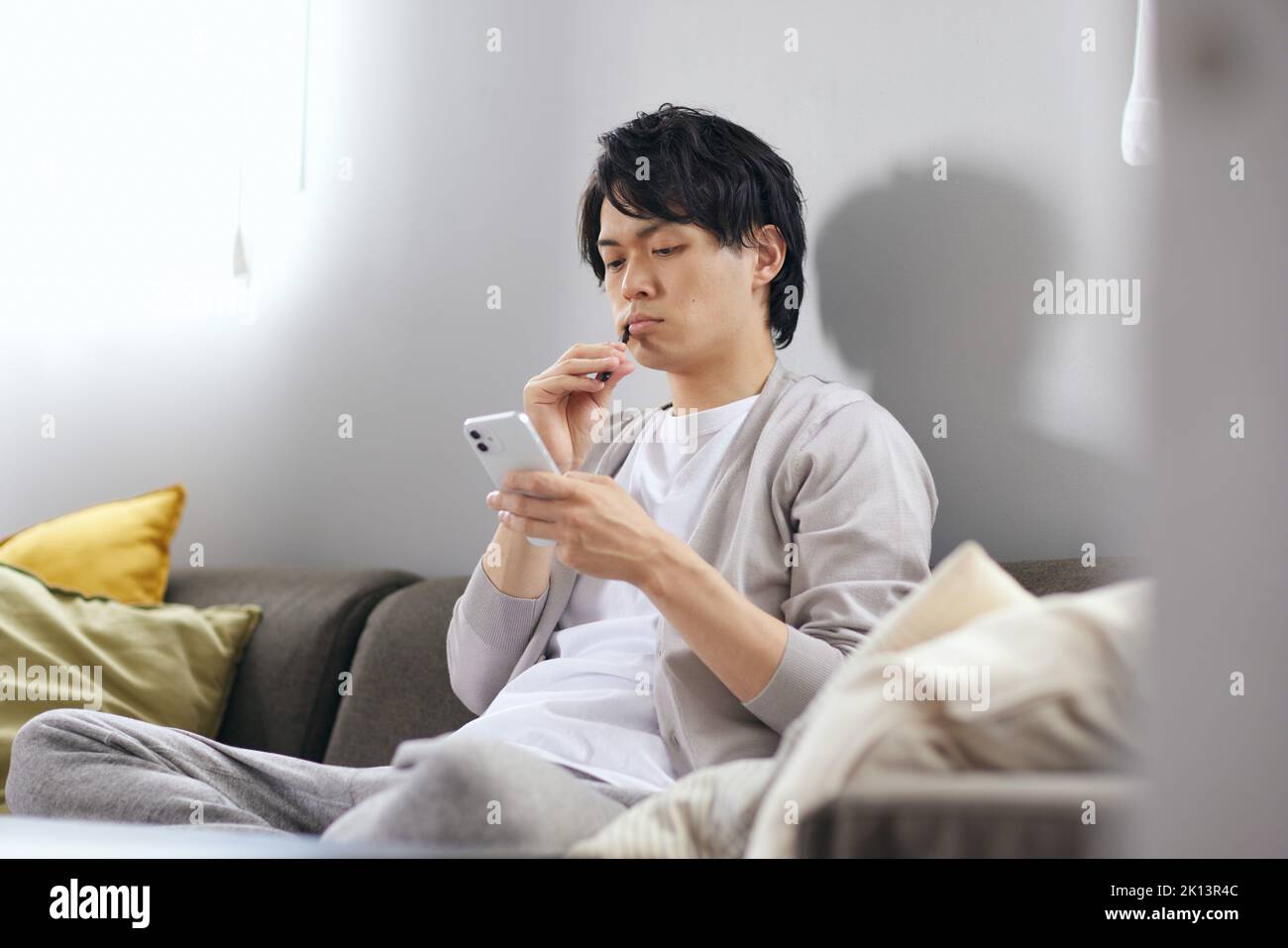 Japanese man brushing teeth on the sofa Stock Photo - Alamy
