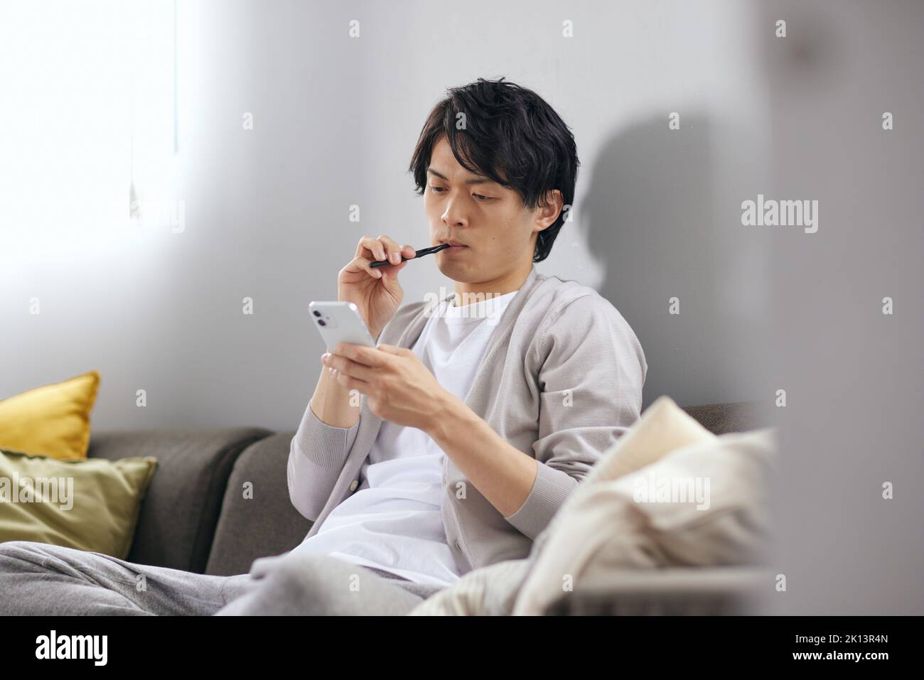 Japanese man brushing teeth on the sofa Stock Photo - Alamy