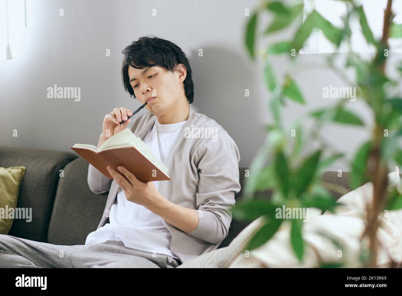 Japanese man brushing teeth on the sofa Stock Photo - Alamy