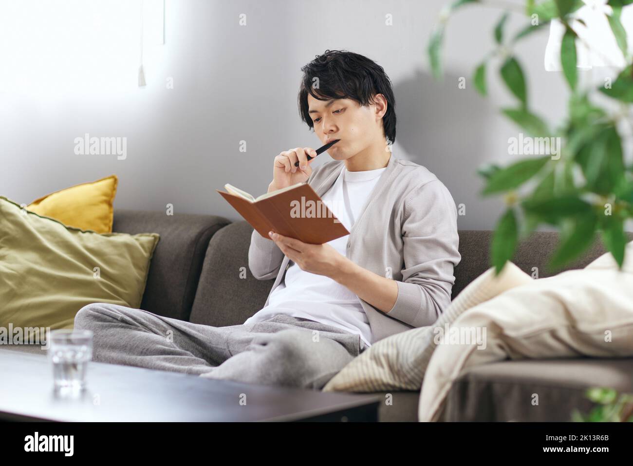 Japanese man brushing teeth on the sofa Stock Photo - Alamy