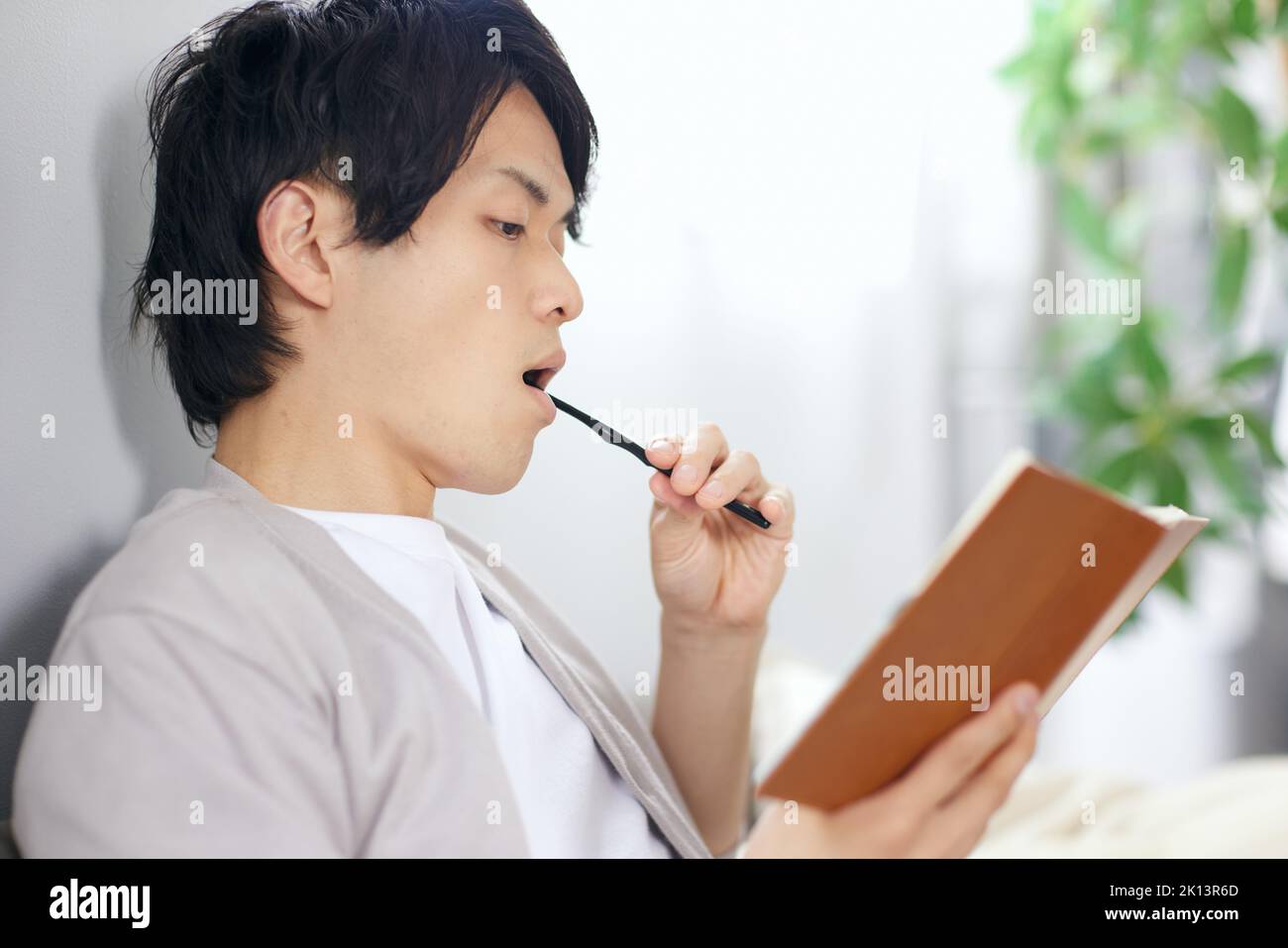 Japanese man brushing teeth on the sofa Stock Photo - Alamy