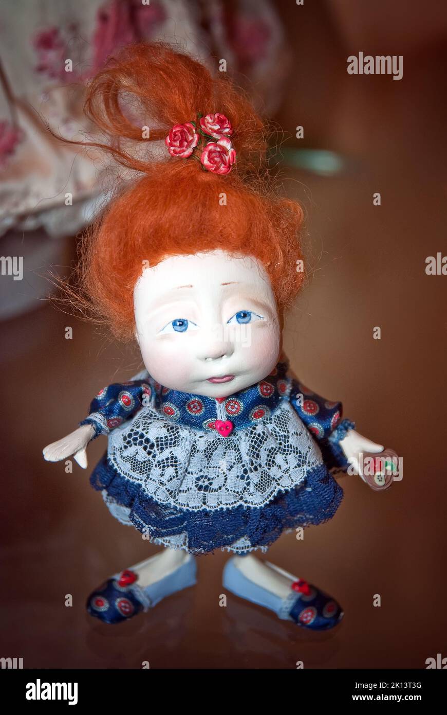 A collectible doll, a tiny girl in blue lacy dress, is on display at ...