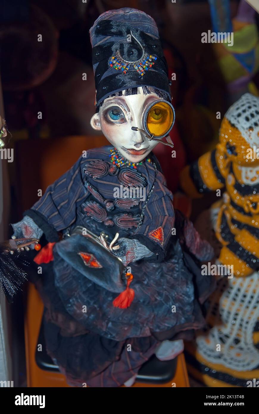 A collectible doll, a boy in kimono and yellow monocle, is on display ...