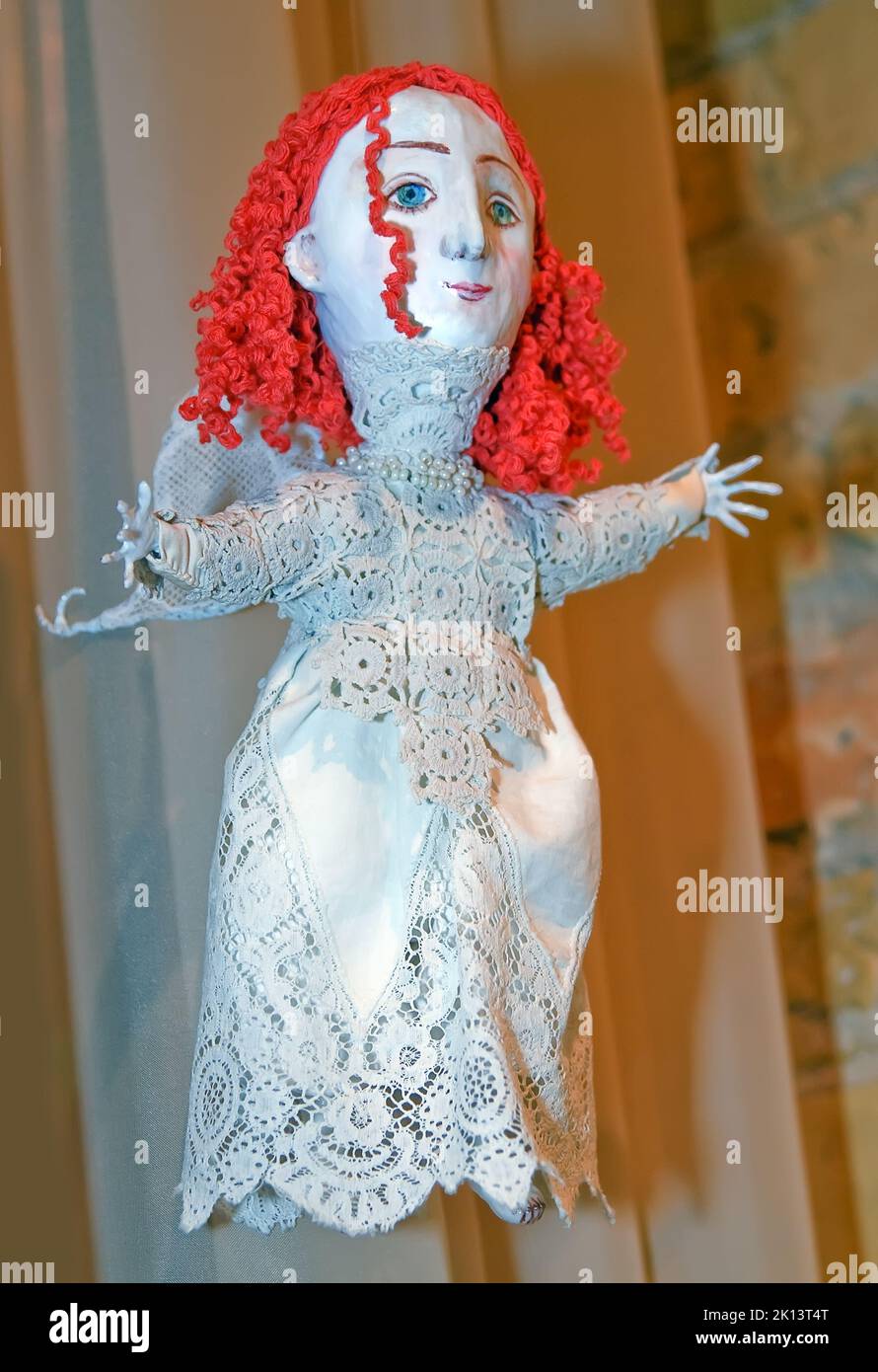 A collectible doll, which resembles an angel with orange hair, is on ...