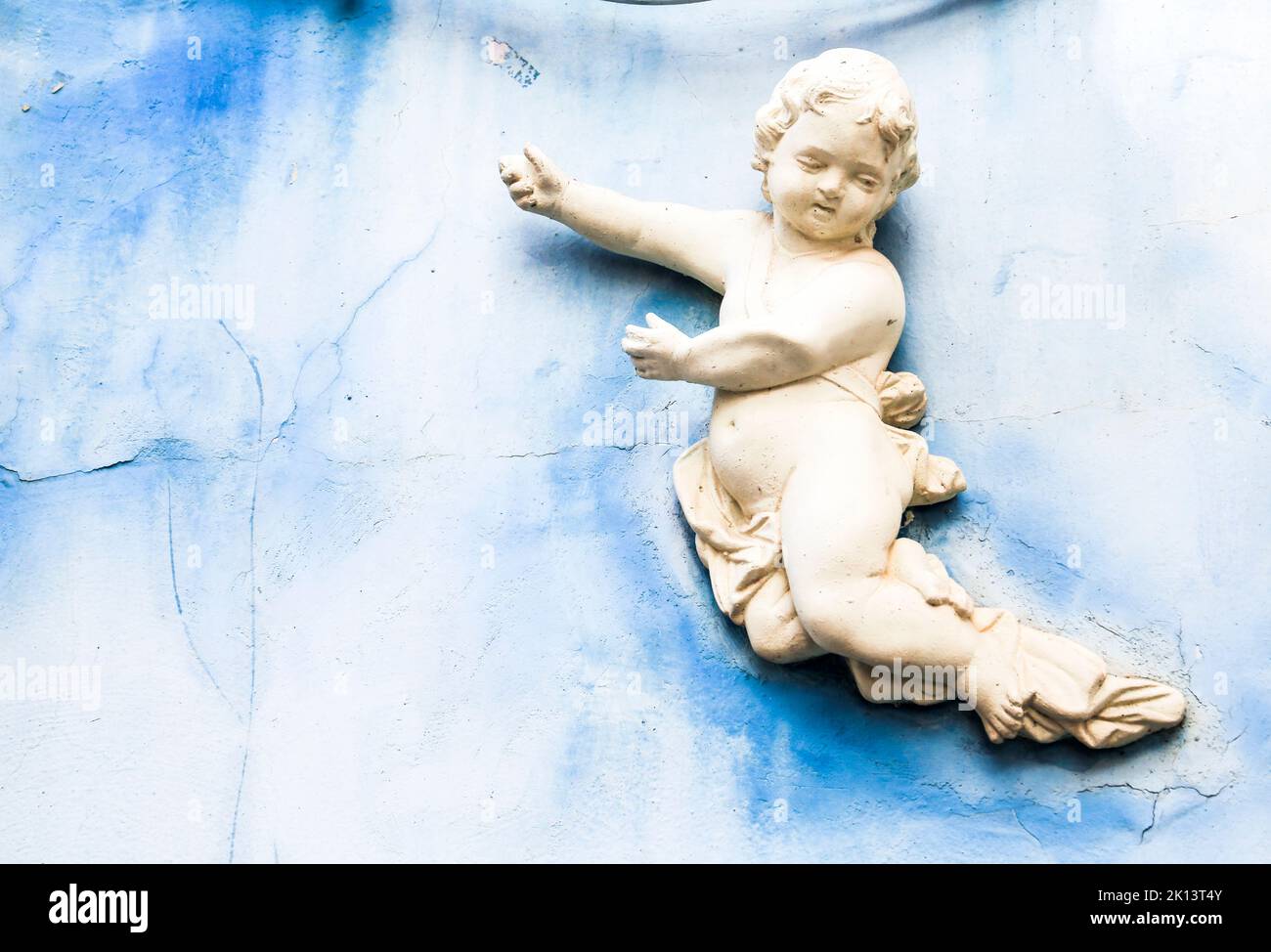 Decorative stone angels on wall surrounded by electric cables in Spain ...