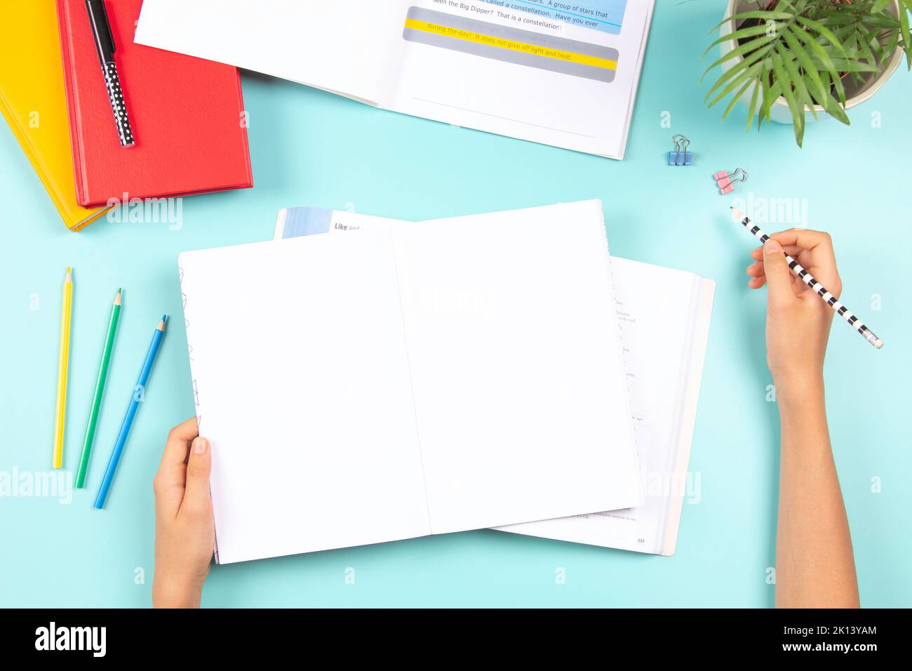 Child doing homework. Top view to desk with open blank notebook, books ...