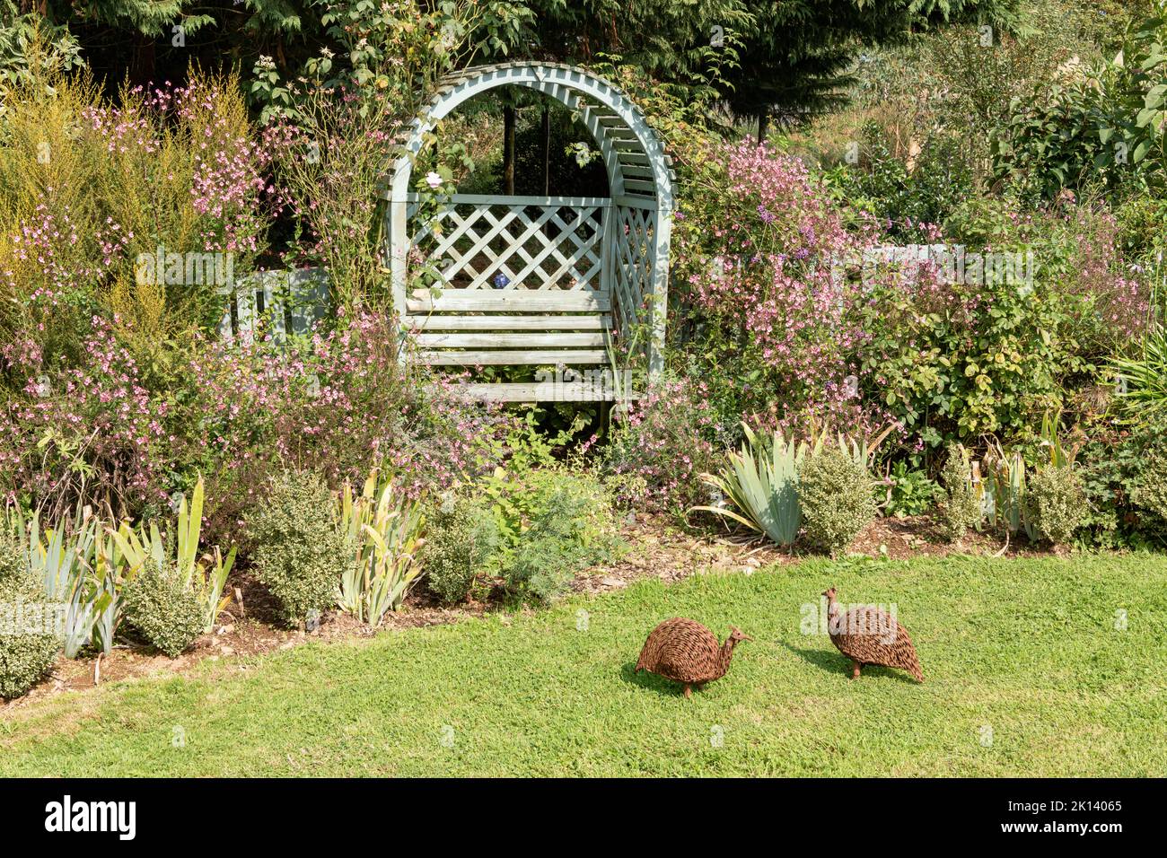 Beautiful garden seat with arch in an English country garden with two ...