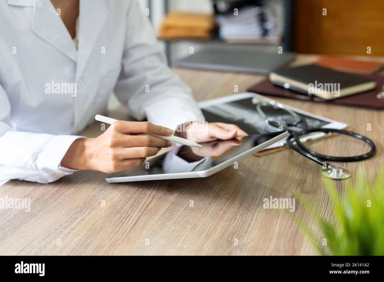 Cropped of female doctor using gadgets at workplace, holding smartphone ...