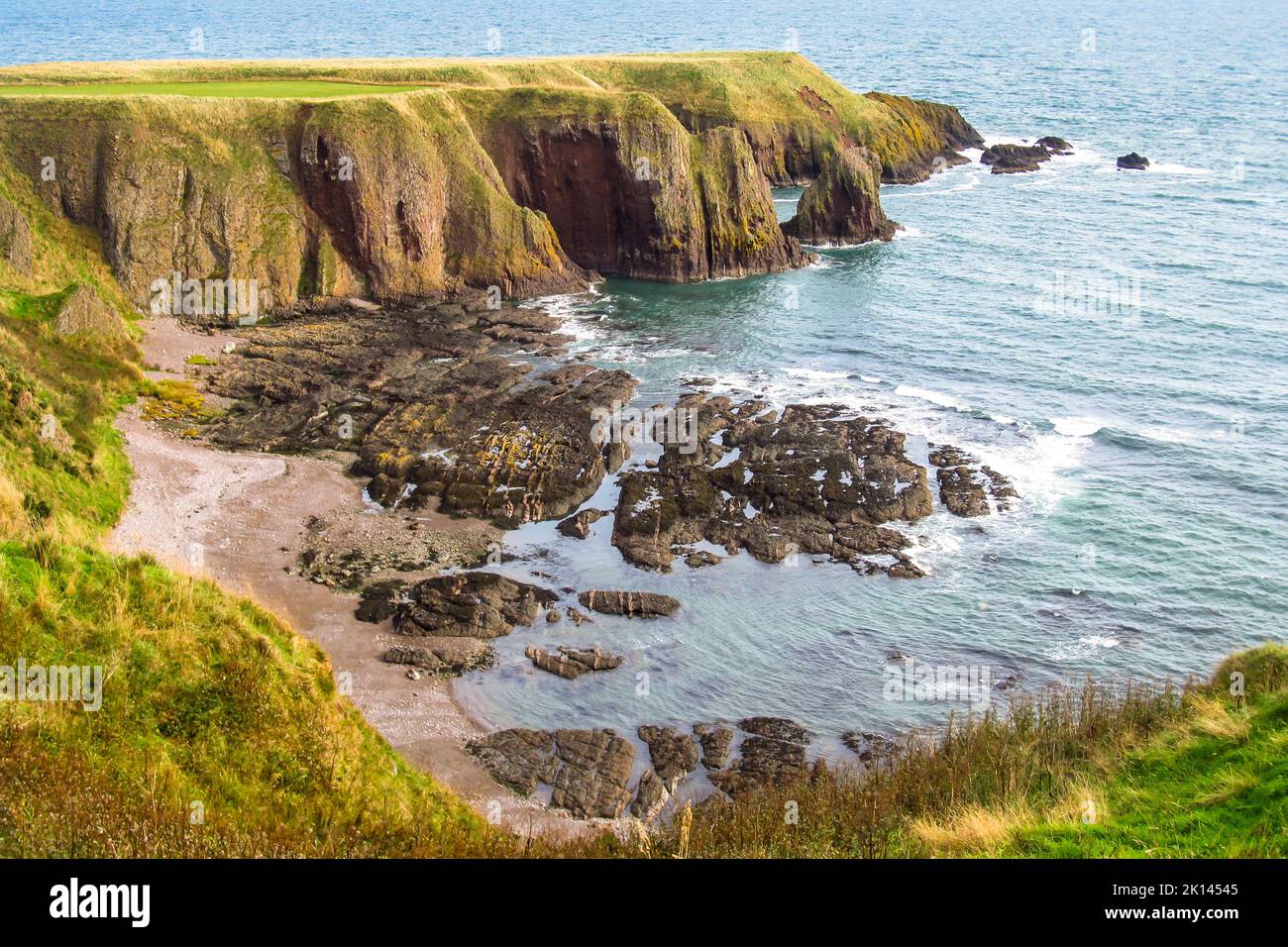 Sheltered cove between the high basalt cliffs of the Northern Scottish ...