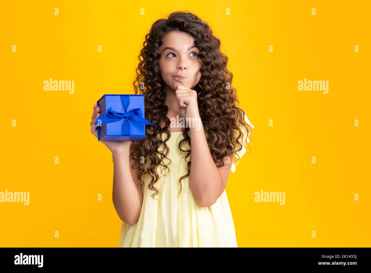 Child with gift present box on isolated studio background. Gifting for ...