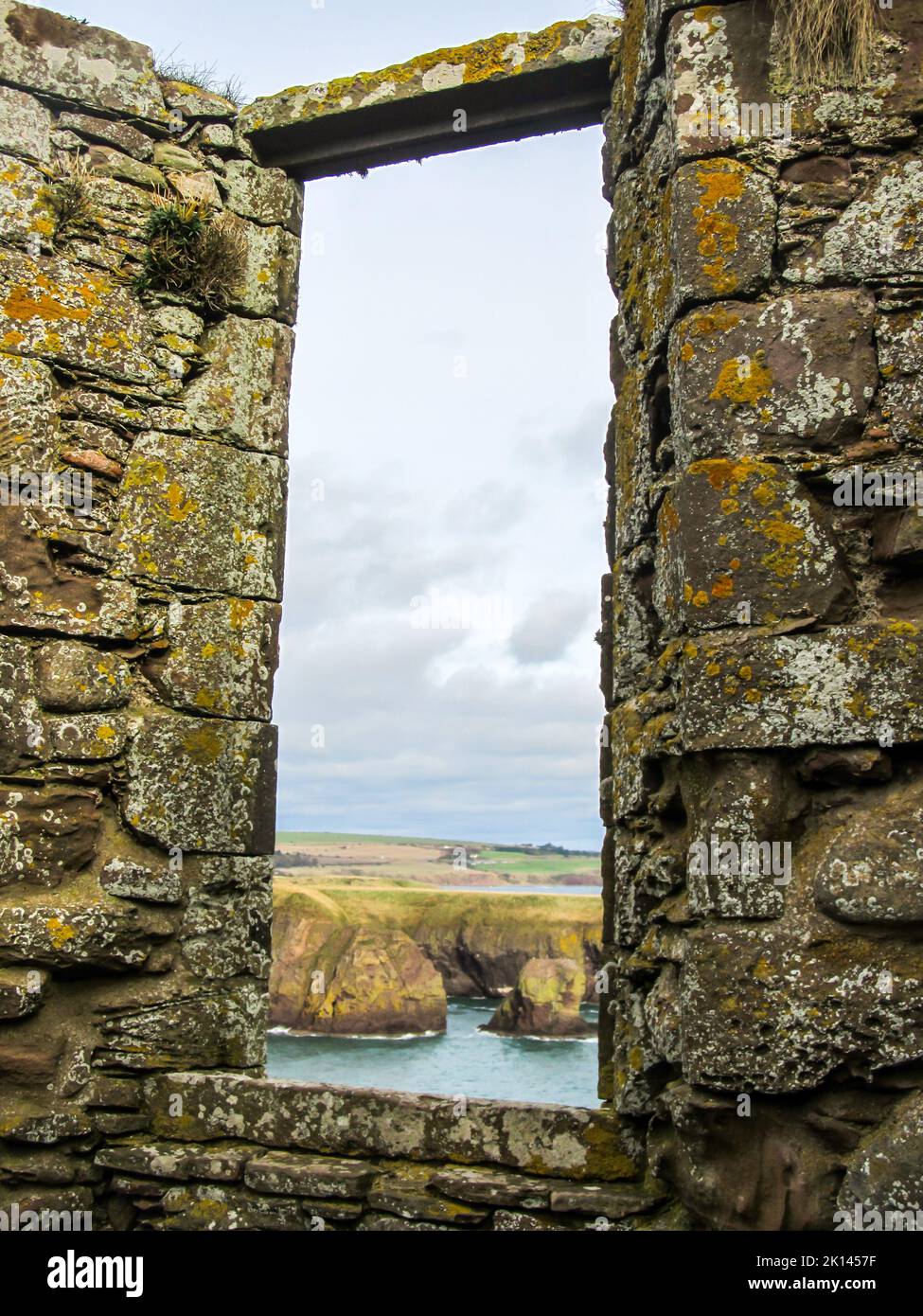 Looking through the window of an old castle ruin over the rugged ...
