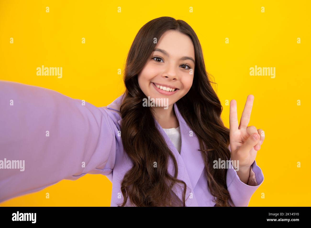 Fashion teen girl in trendy wear making selfie posing on yellow ...