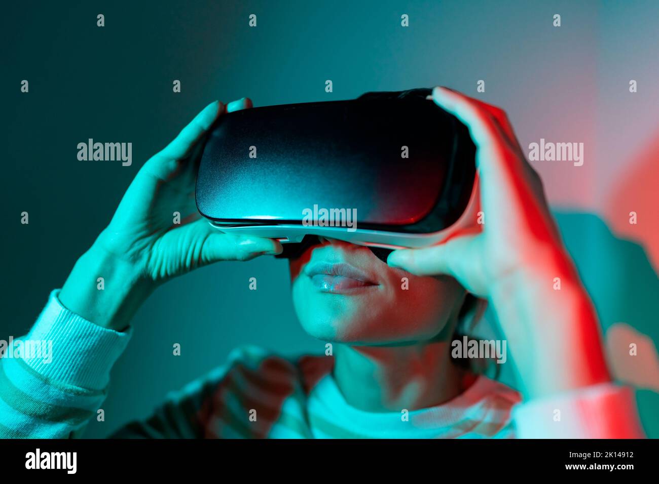 Amazed young woman testing modern high-tech VR helmet, getting 3D ...