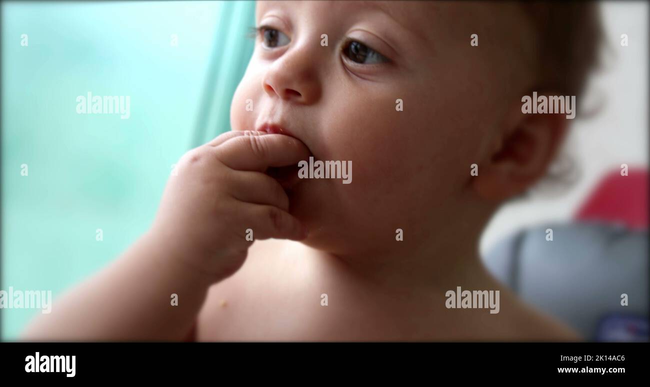 Cute baby portrait eating and spitting food. Close-up infant child face ...