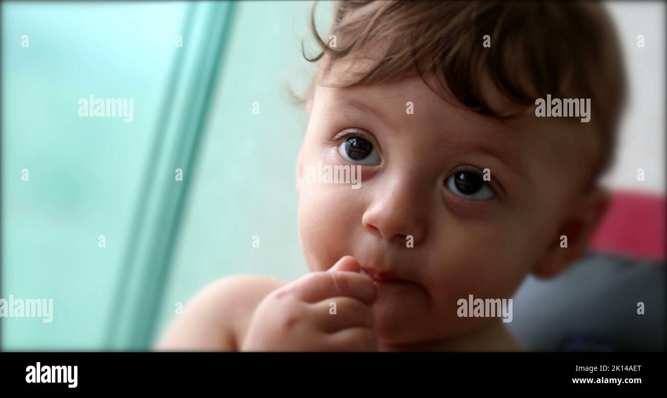 Cute baby portrait eating and spitting food. Close-up infant child face ...