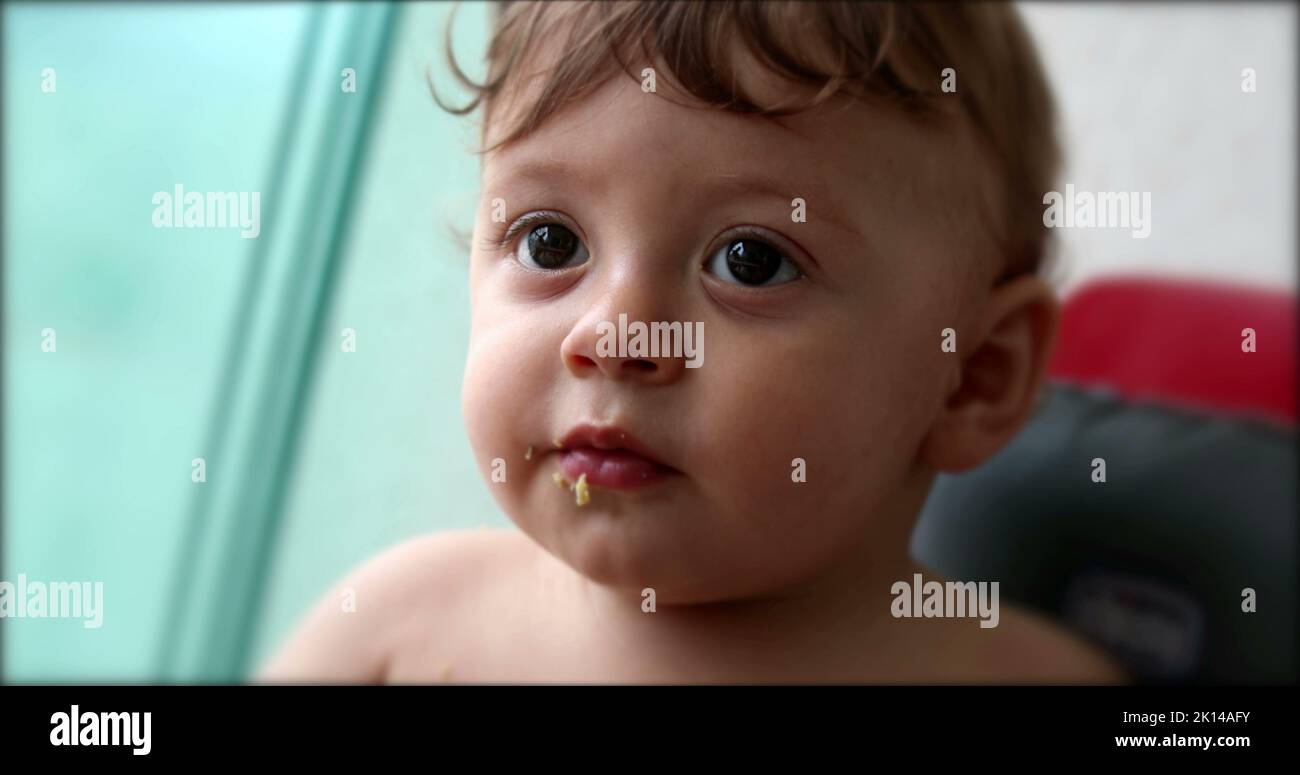 Cute baby portrait eating and spitting food. Close-up infant child face ...