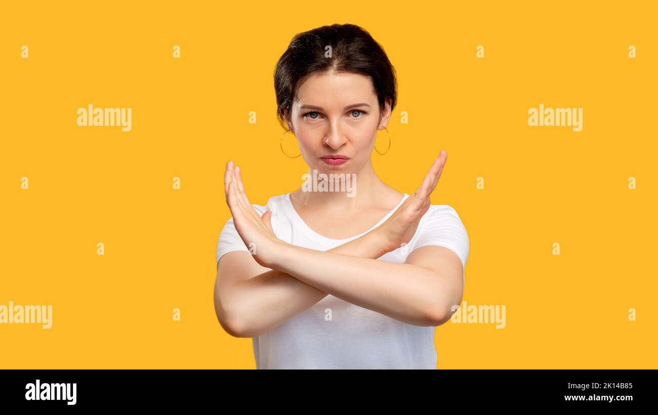 Stop sign. Forbidden gesture. Angry woman crossing hands looking at ...