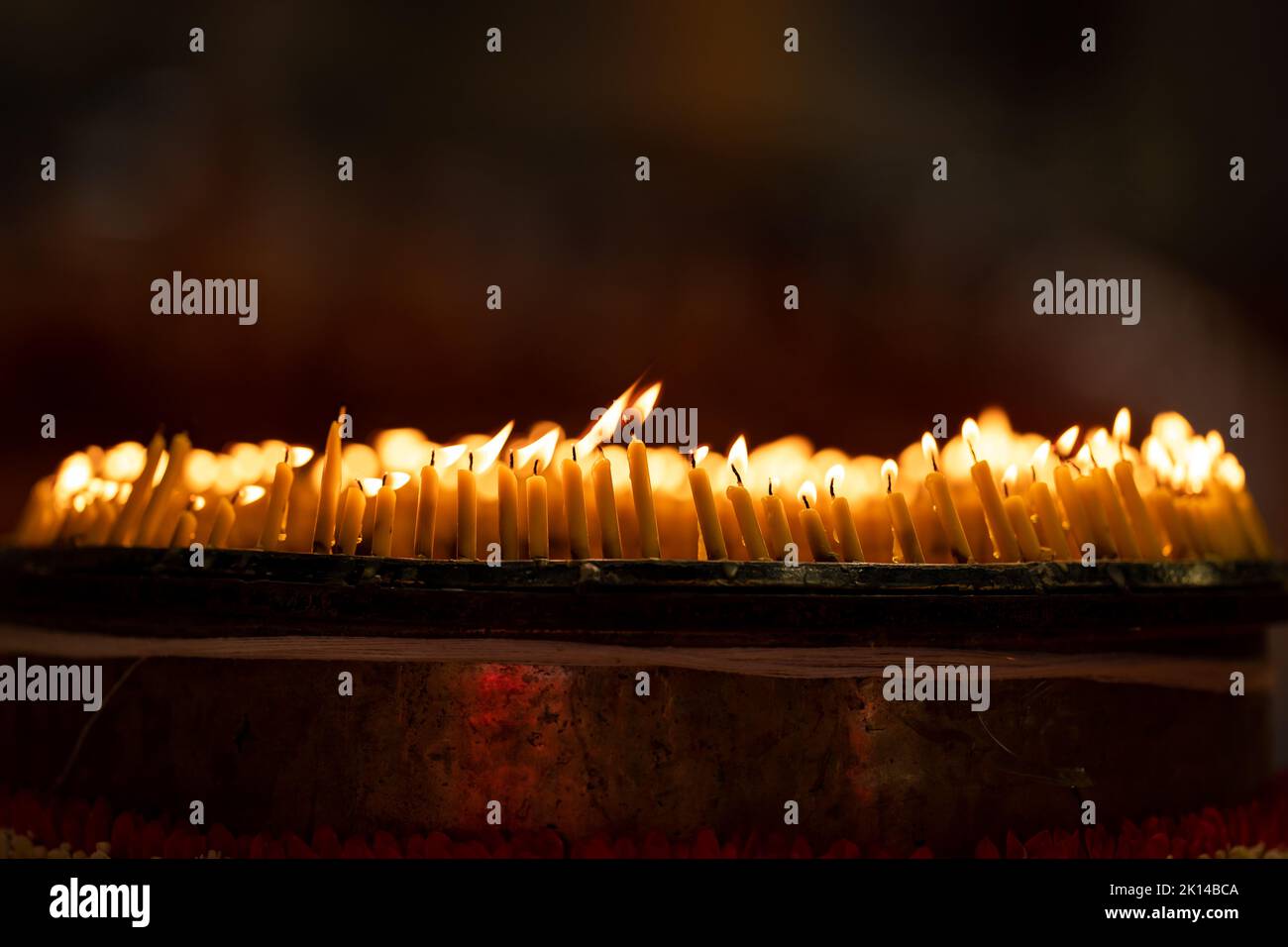 lighted candles laid out in circle in the dark with small white shadow ...