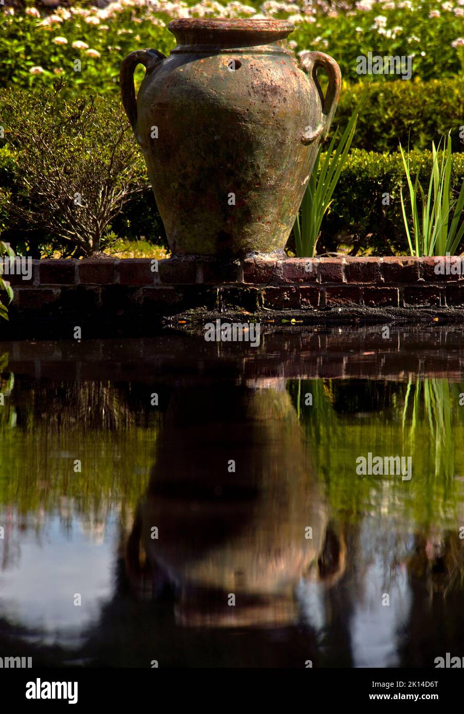 Pottery urn in garden near water feature Stock Photo - Alamy
