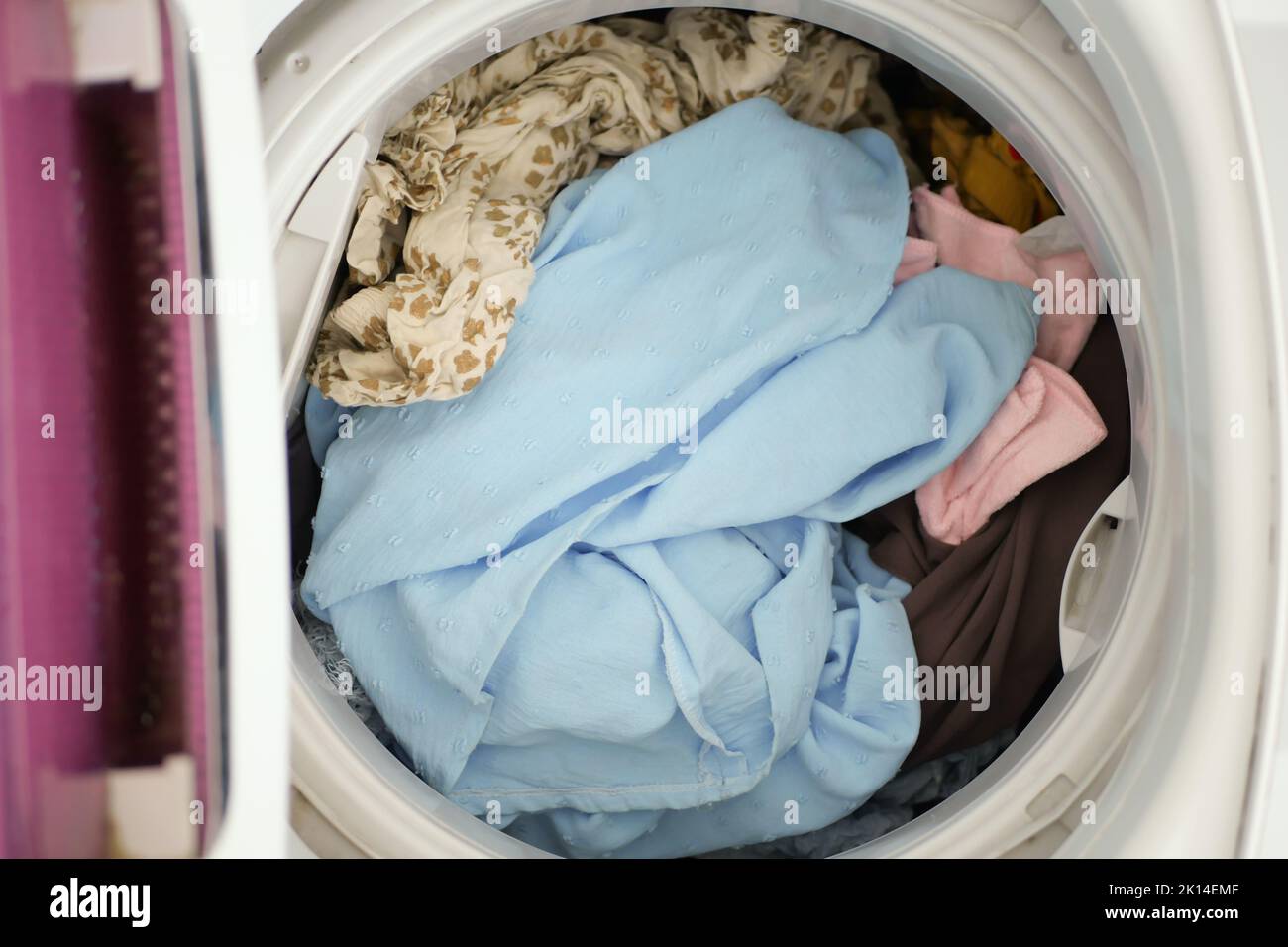 colorful cloths into washing machine Stock Photo - Alamy