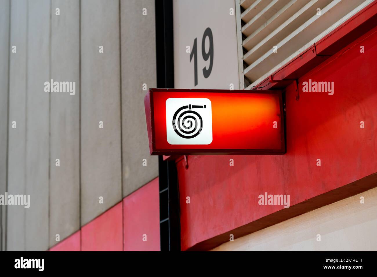 A fire equipment sign installed on a wall. Red light on to be ...