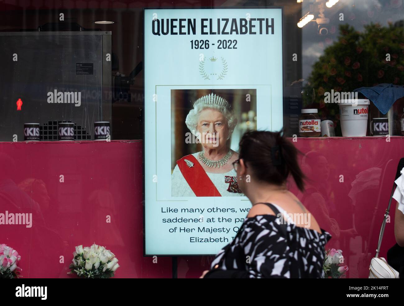 A woman looks at a photograph of the recently deceased Queen Elizabeth ...
