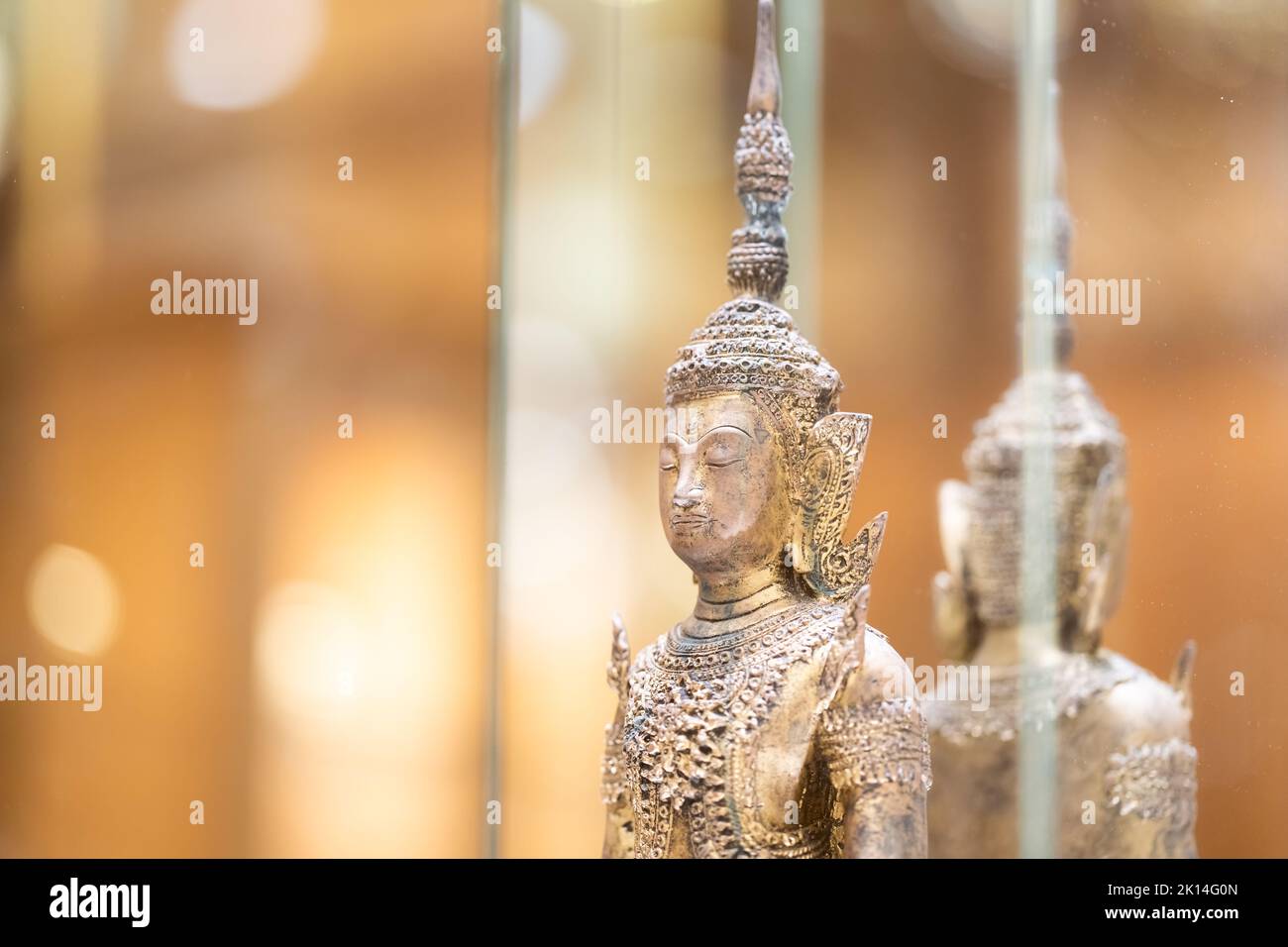 Deity statue standing straight made of brass, wearing gold costume with ...