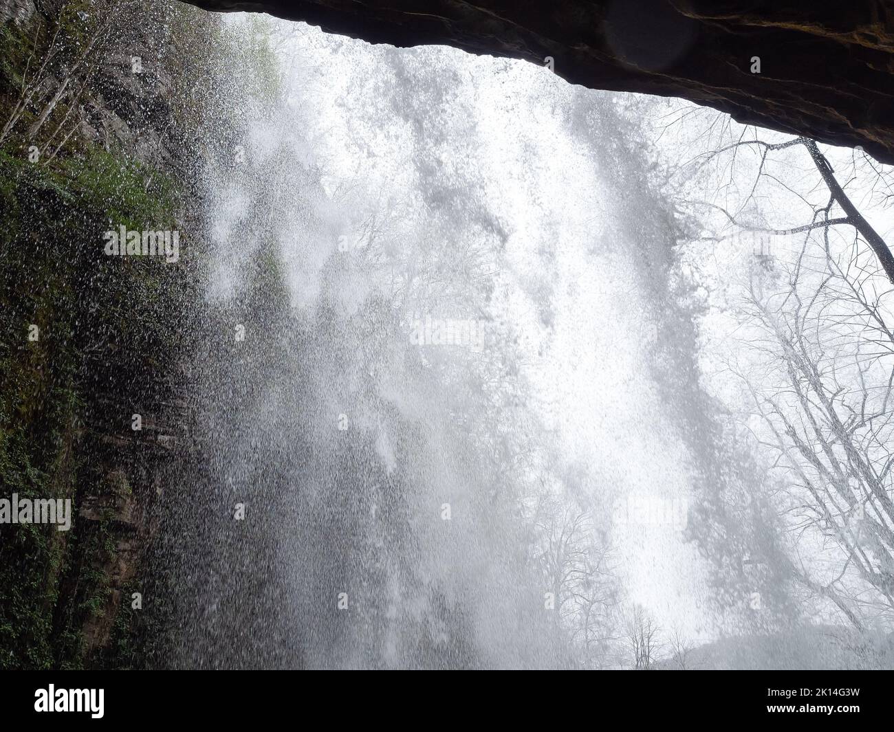 View of the waterfall under the rock. Motion blur Stock Photo - Alamy