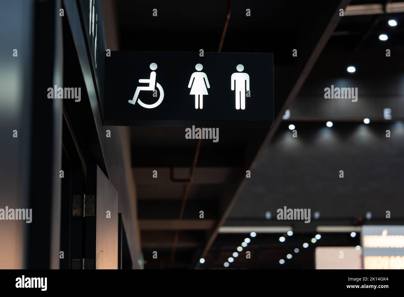 A sign of restroom lighten in white standout from a black plate. The ...