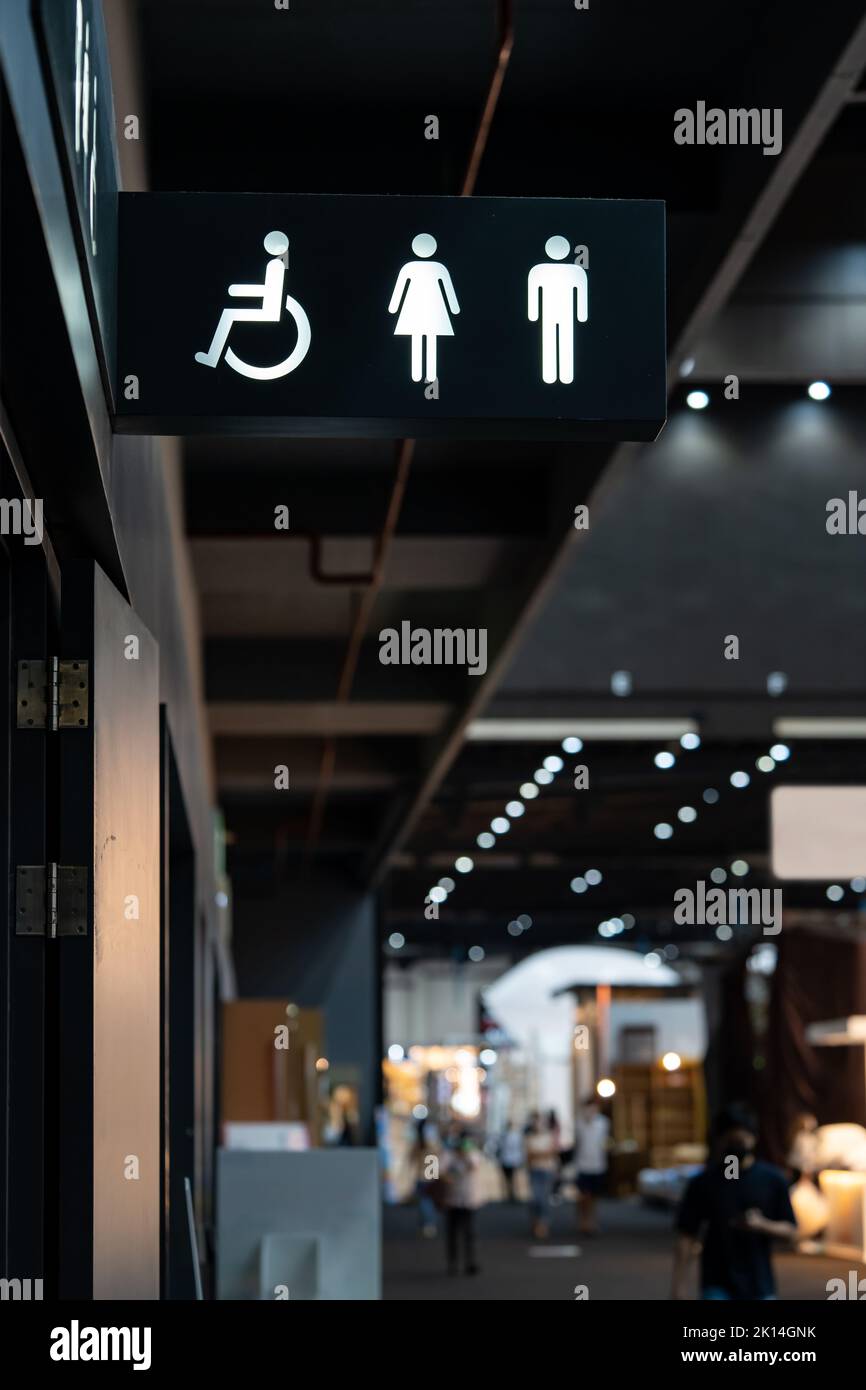 A sign of restroom lighten in white standout from a black plate. The ...
