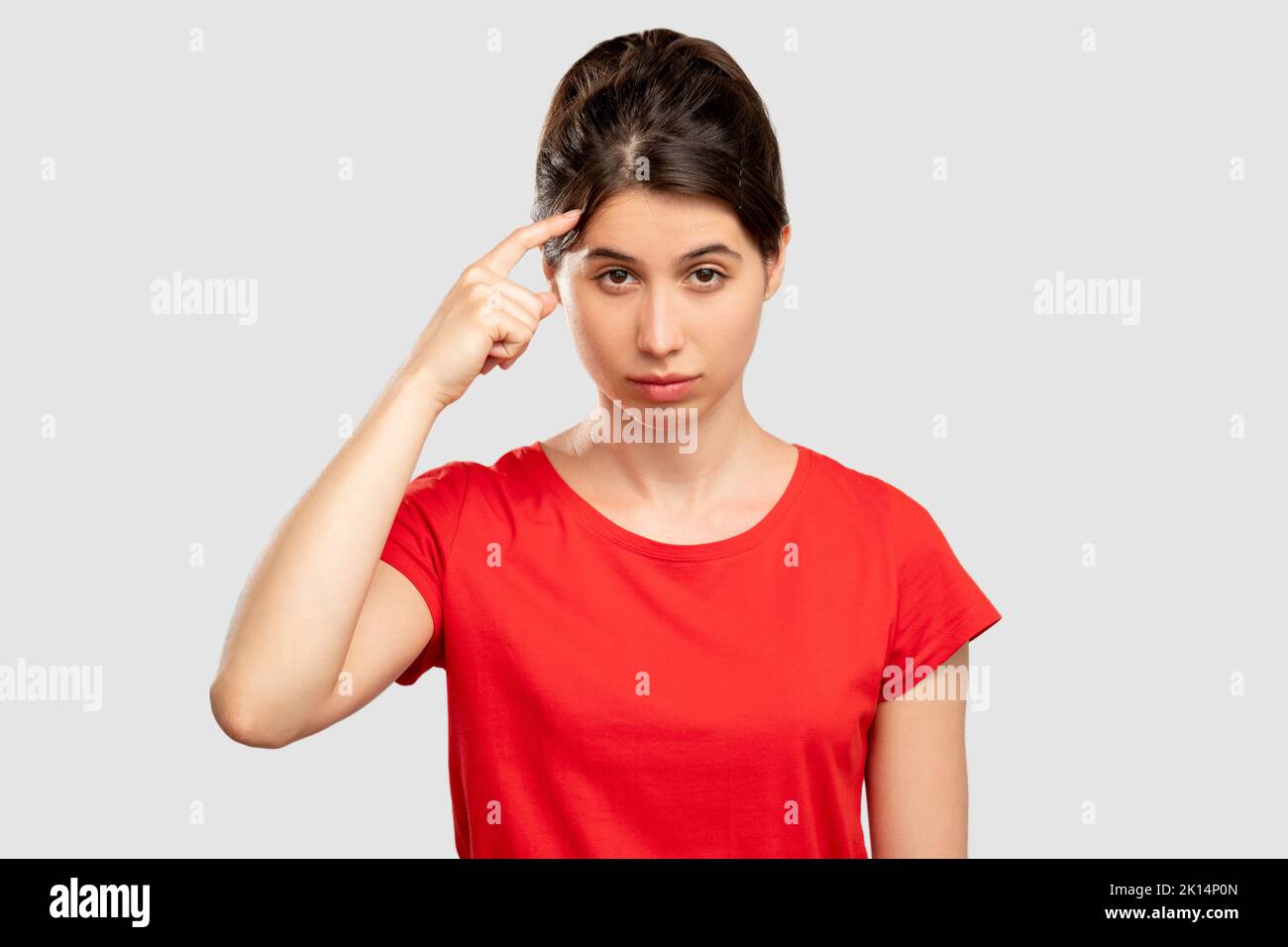Silly idea. Stupid gesture. Doubtful woman holding finger on head ...