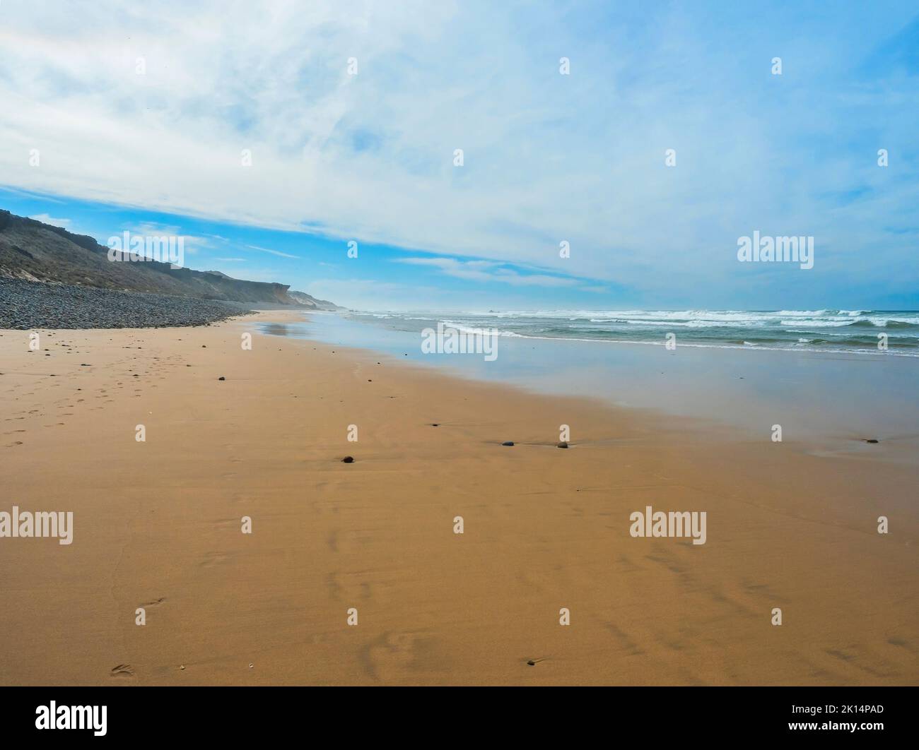 View of empty Praia do Queimado beach with ocean waves and sharp rocks ...