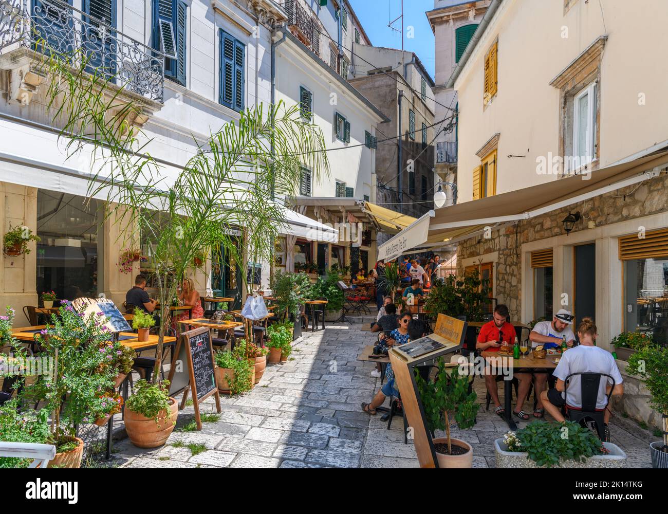 Cafes and restaurants on a narrow street in in the historic centre of ...