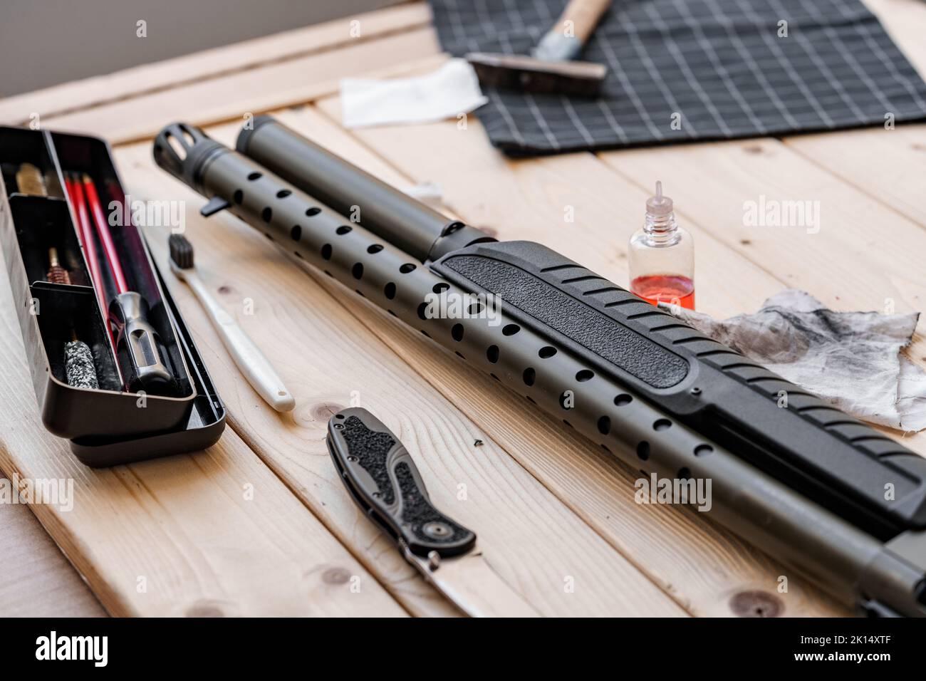 Disassembled rifle with cleaning tools on table of weapons workshop ...