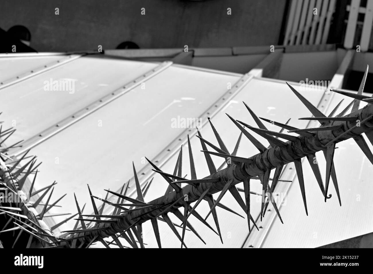 Sharp metal spikes on a metal pole secured to the top of a fence as a ...