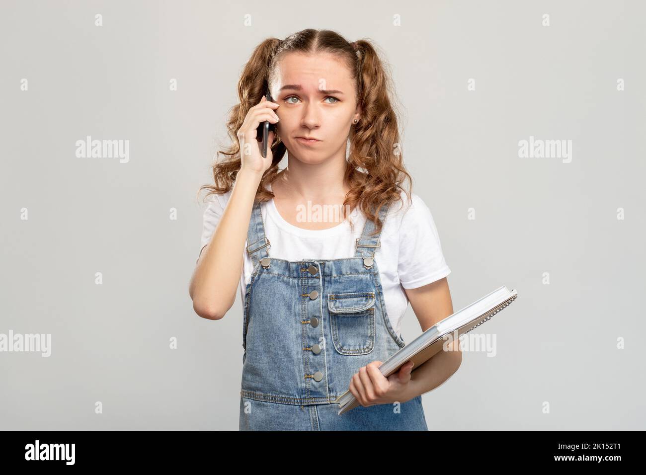Skeptic girl portrait. Disturbing phone call. Confused student with ...