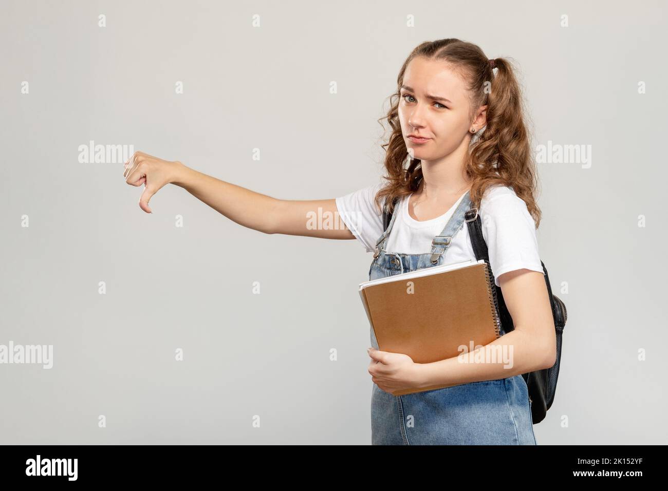 Disappointed student portrait. Exam failure. Skeptic girl with books ...